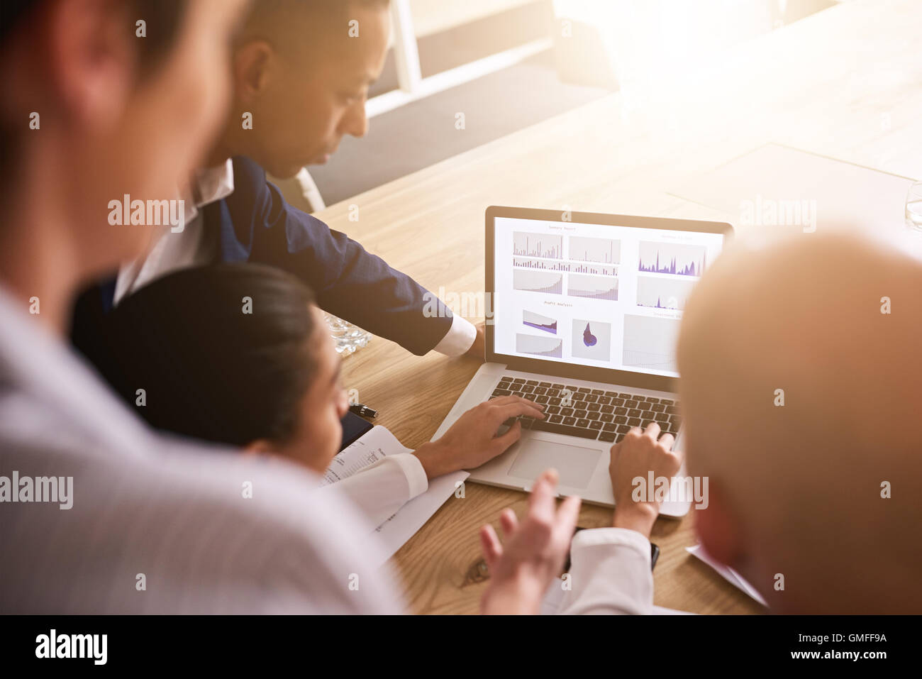 Group of business people looking at graphs on a laptop Stock Photo - Alamy