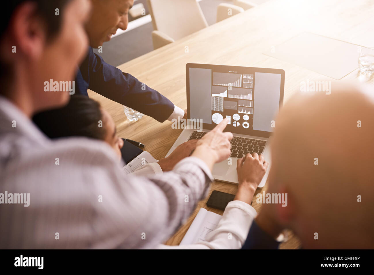 Group of business people looking at graphs on a laptop Stock Photo - Alamy