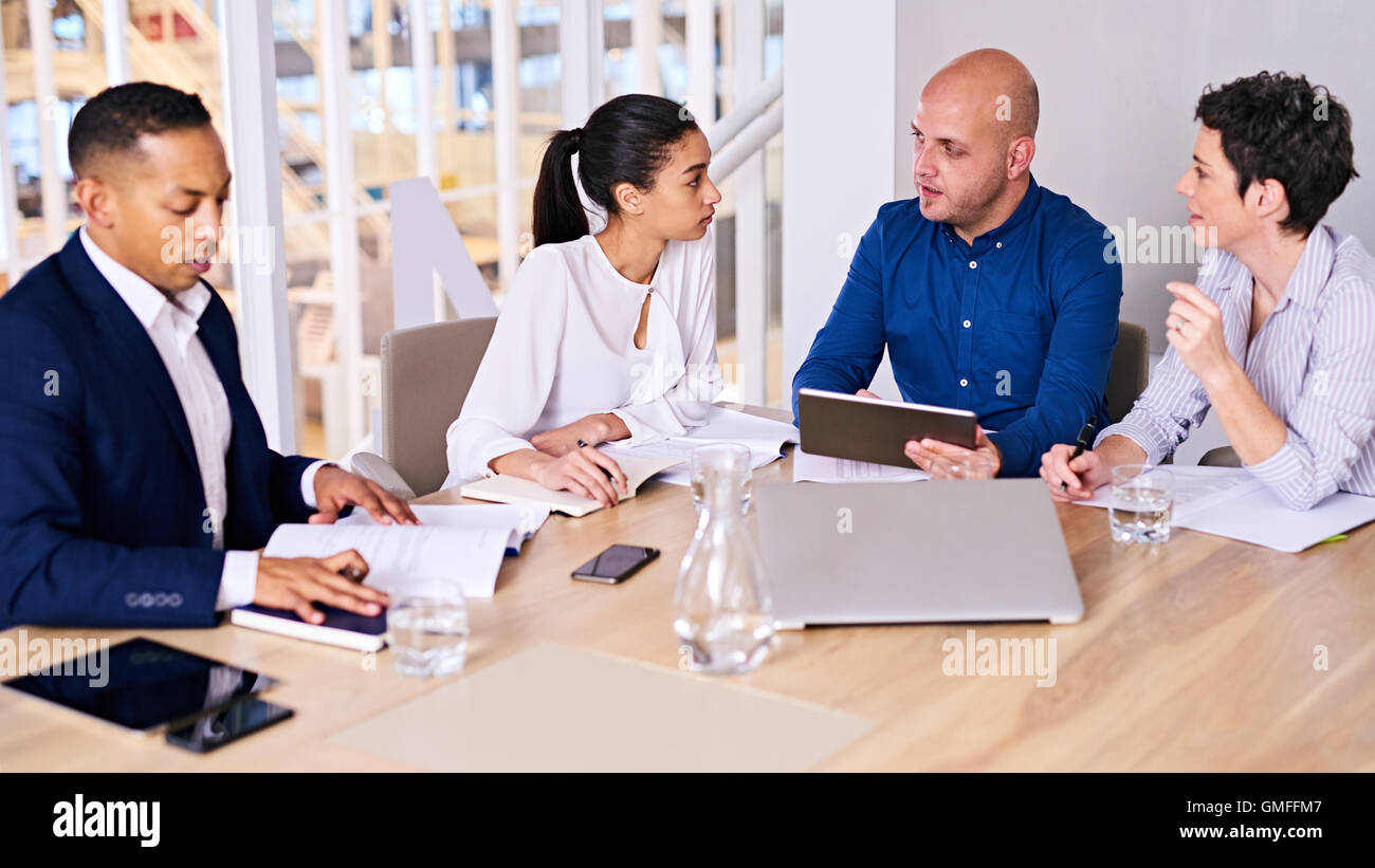 Young business people busy talking to each other in meeting Stock Photo ...