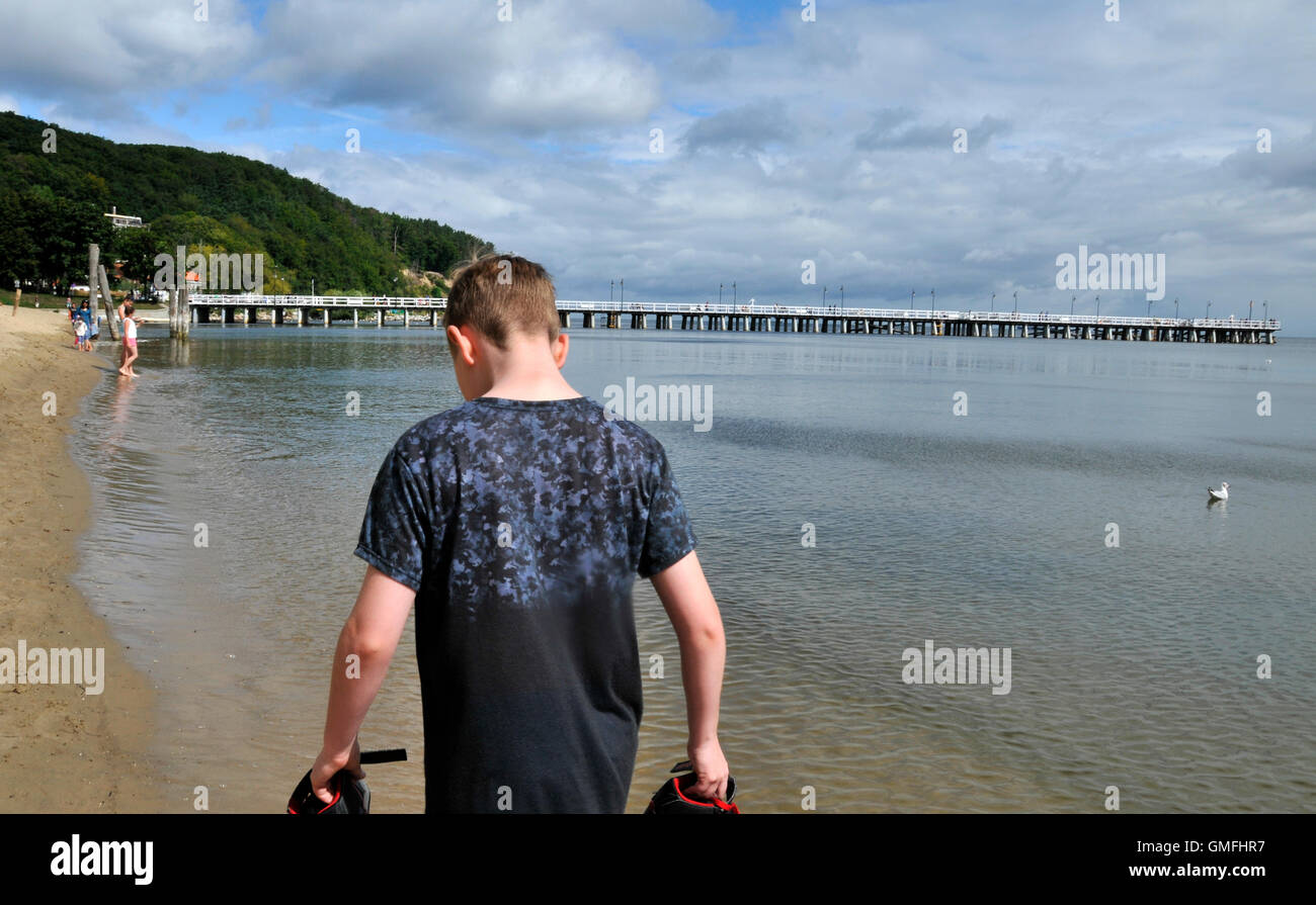 boy walking on beach pier Stock Photo - Alamy
