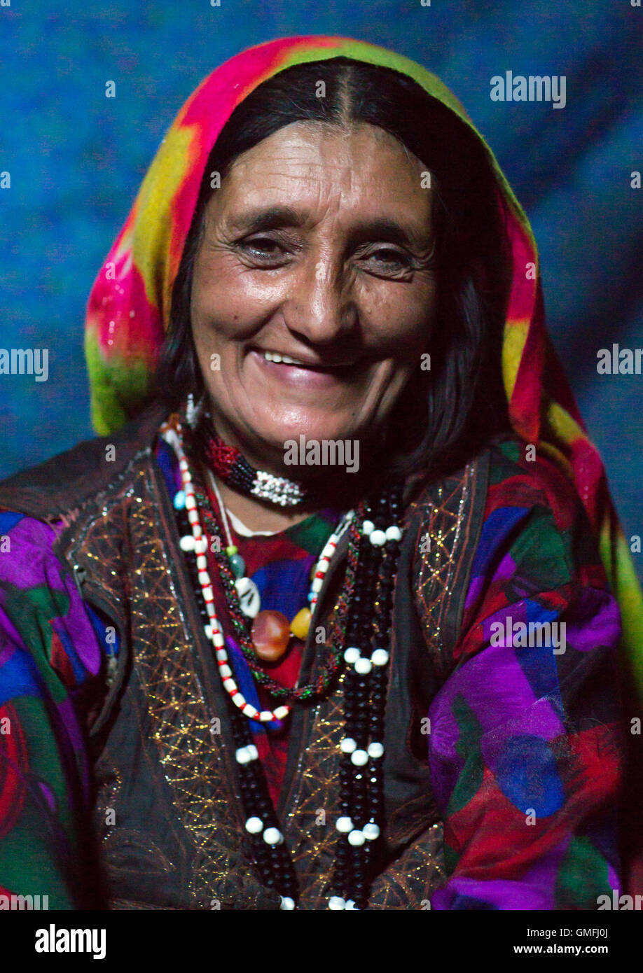 Portrait of a smiling afghan woman in pamiri traditional clothing ...