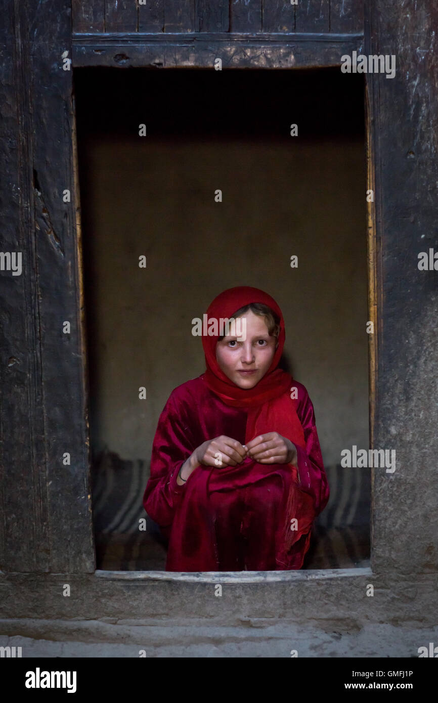 Portrait of an afghan girl with pale skin wearing red clothes ...