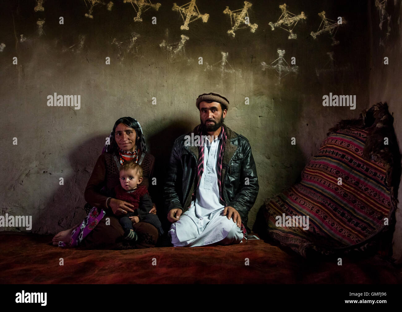 Afghan family inside their traditional pamiri house with the walls ...