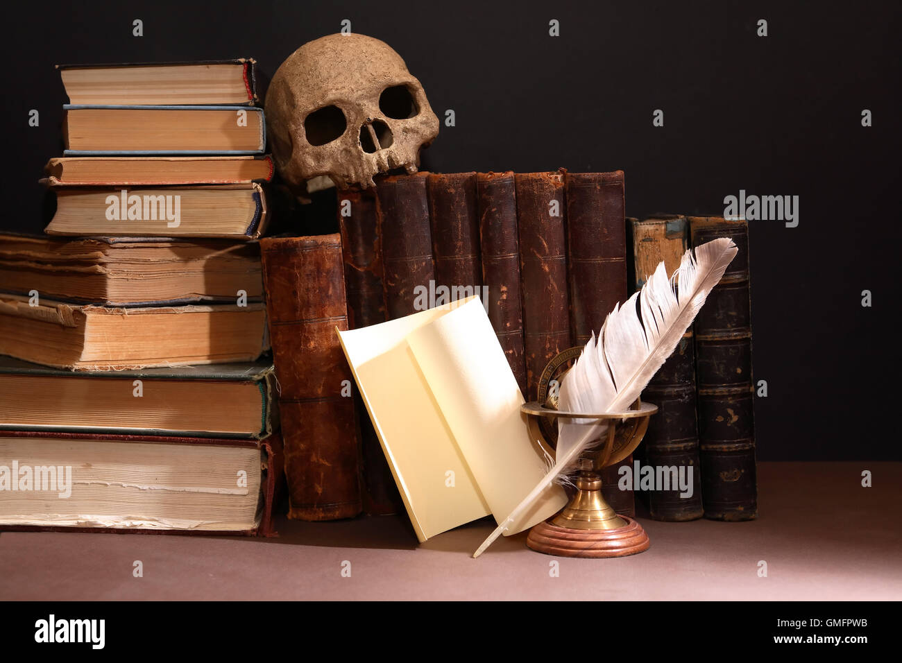 Vintage library. Human skull on old books in a row on dark background ...