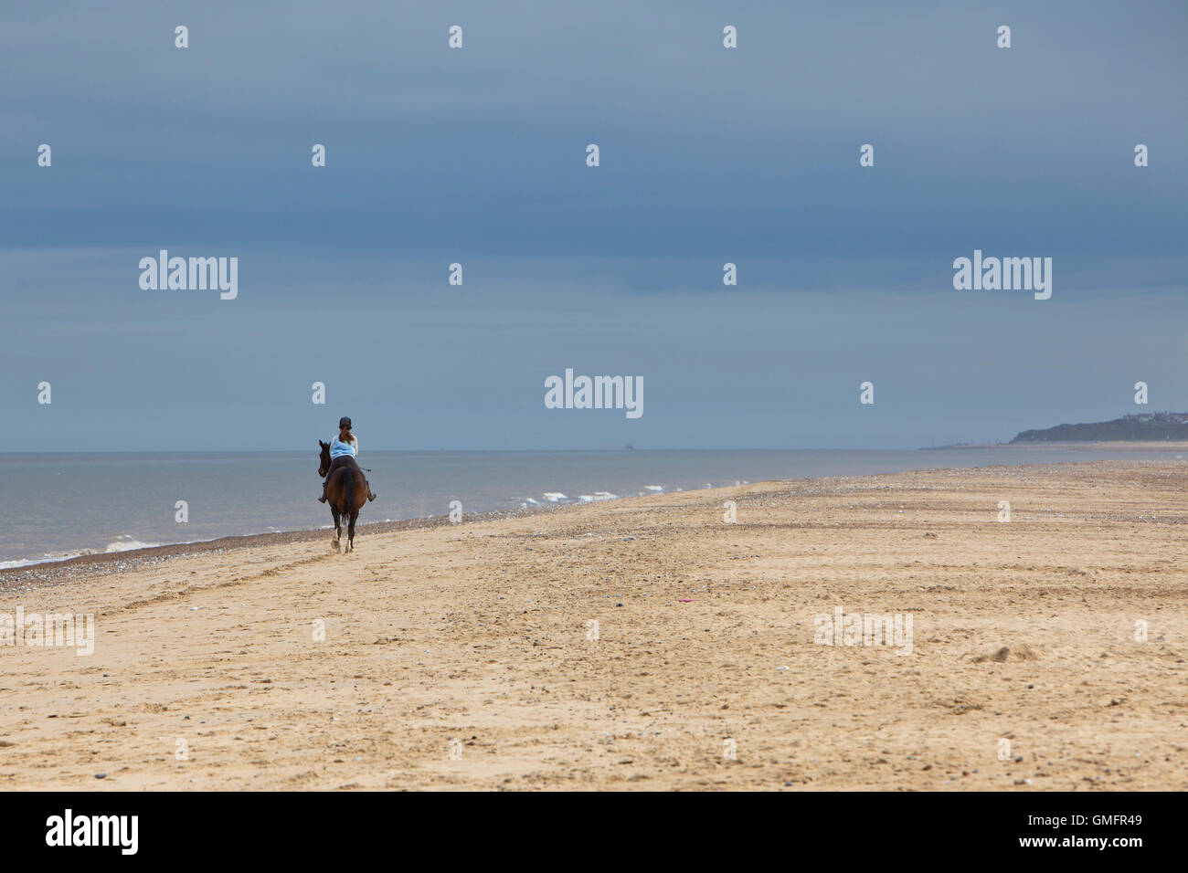 Horse riding along shoreline at the English seaside village of ...
