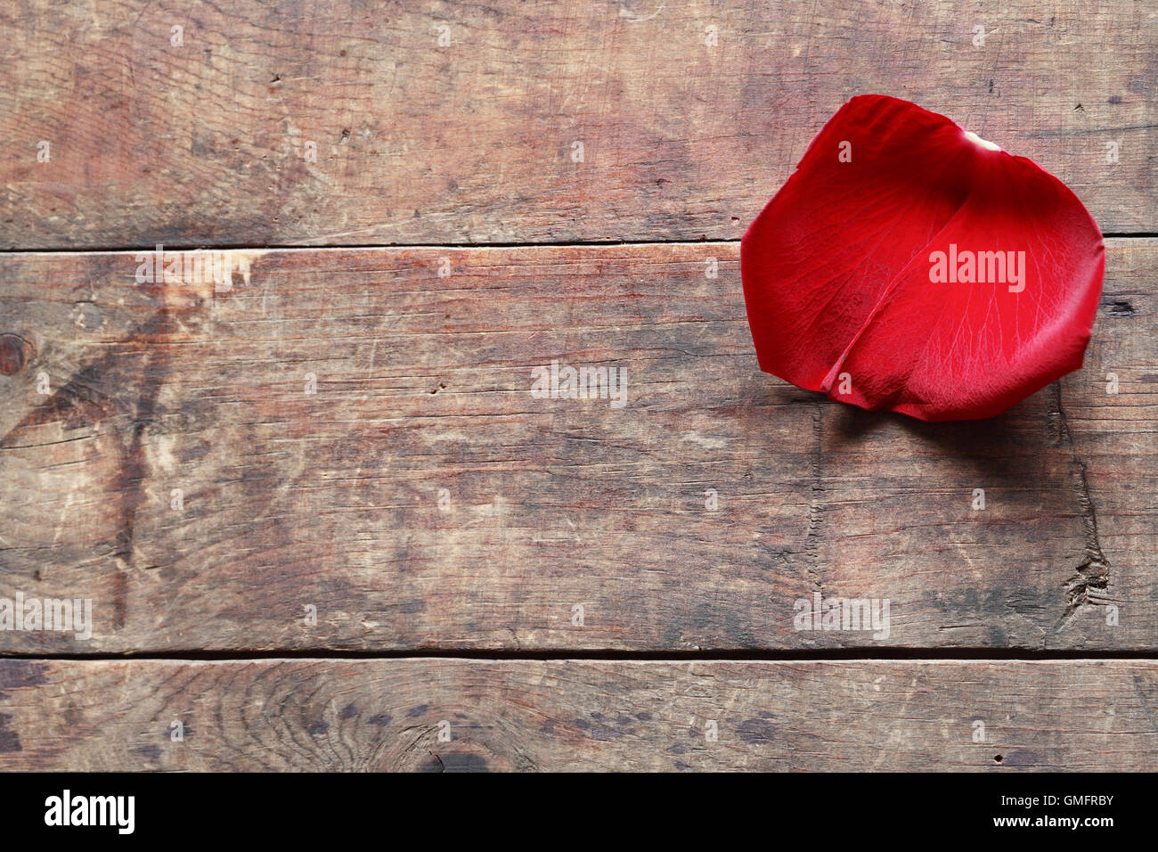 Alone red rose petal on old wooden background with free space Stock ...