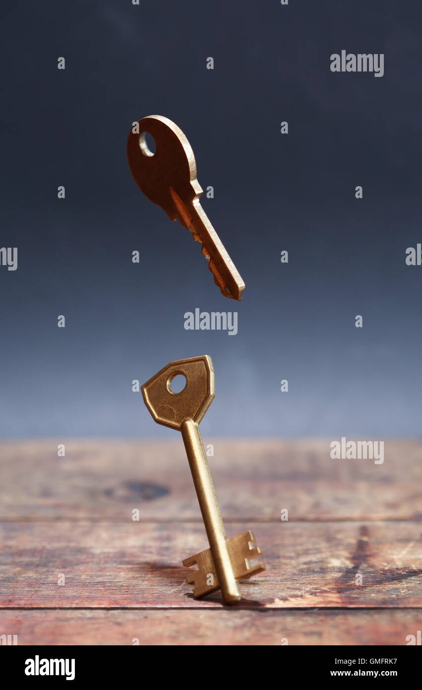 Door key standing on wooden board against dark background Stock Photo ...