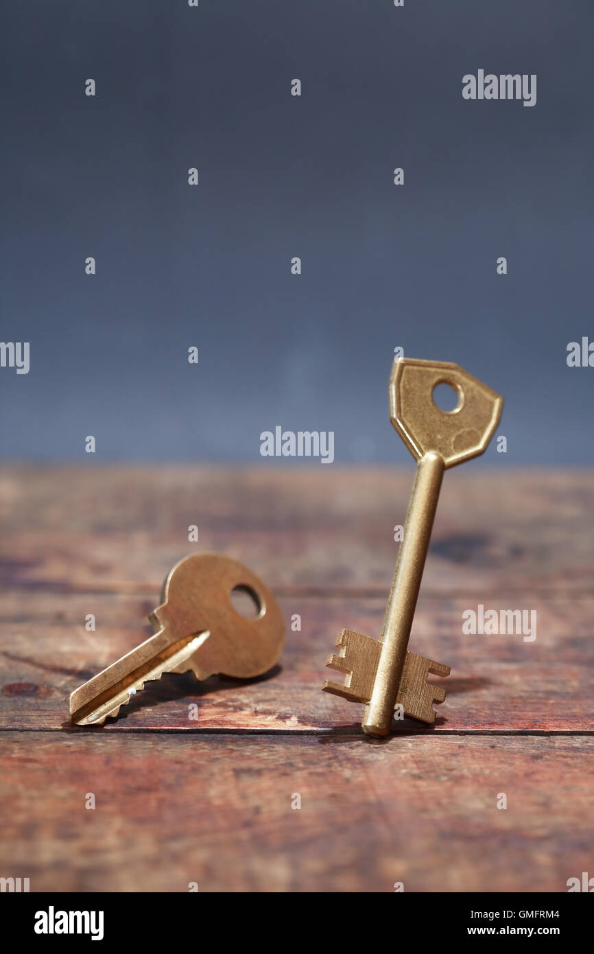 Door key standing on wooden board against dark background Stock Photo ...