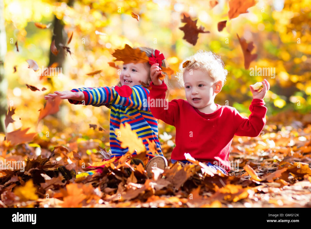 Happy children playing in beautiful autumn park on warm sunny fall day ...