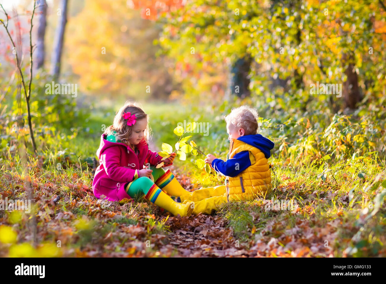Happy children playing in beautiful autumn park on warm sunny fall day ...