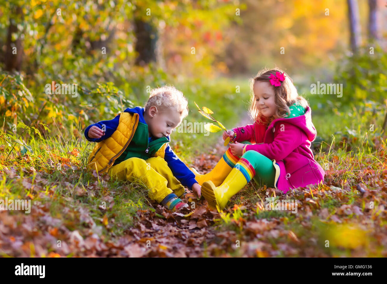 Happy children playing in beautiful autumn park on warm sunny fall day ...
