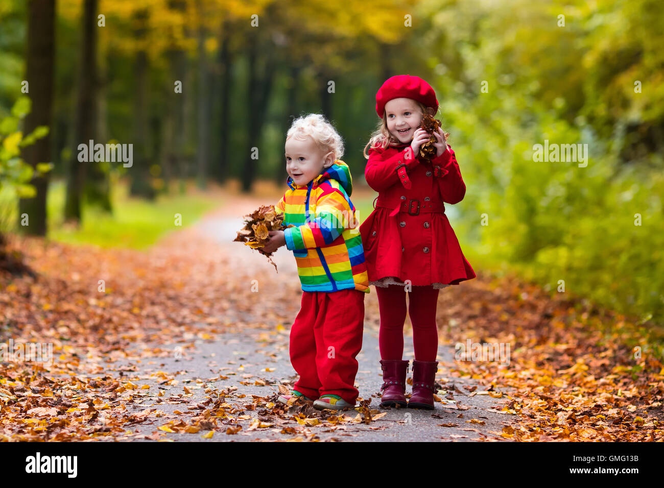 Happy children playing in beautiful autumn park on warm sunny fall day ...