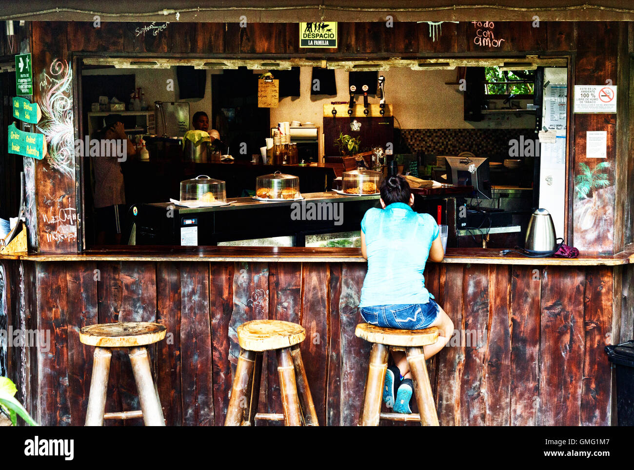 A woman sitting at a bar, Dominical village, Costa Rica, central ...