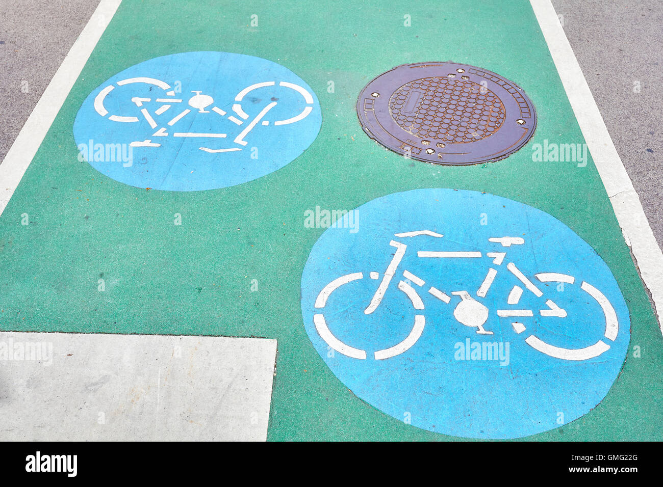 Bicycle path signs on a green painted road Stock Photo - Alamy
