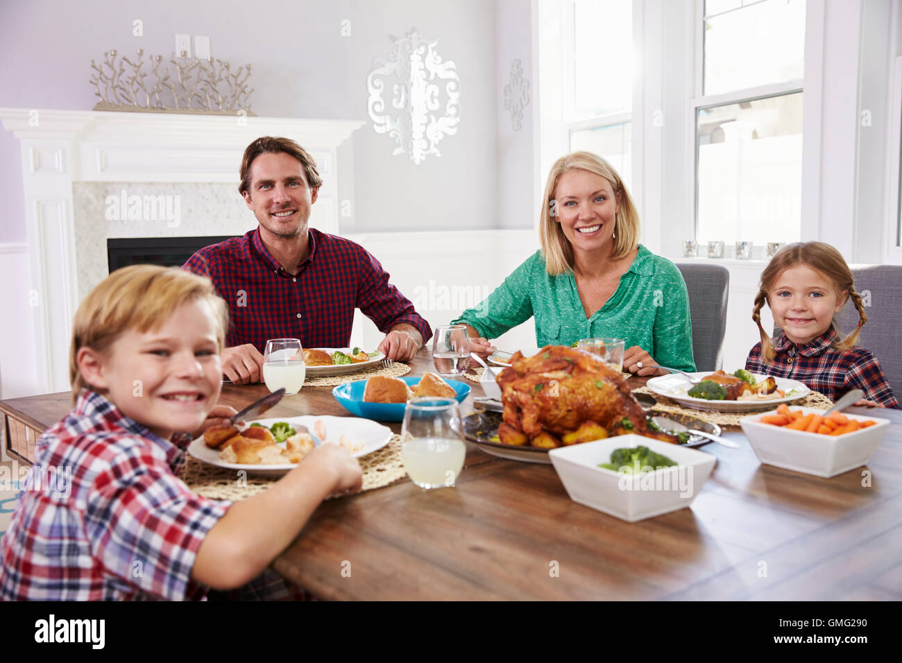 Portrait Of Family Sitting Around Table Eating Meal At Home Stock Photo ...