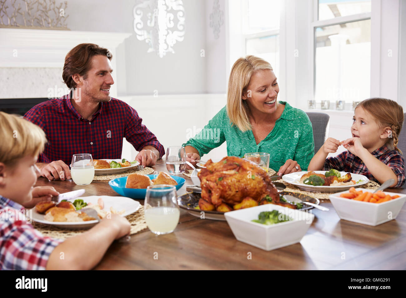 Portrait Of Family Sitting Around Table Eating Meal At Home Stock Photo ...