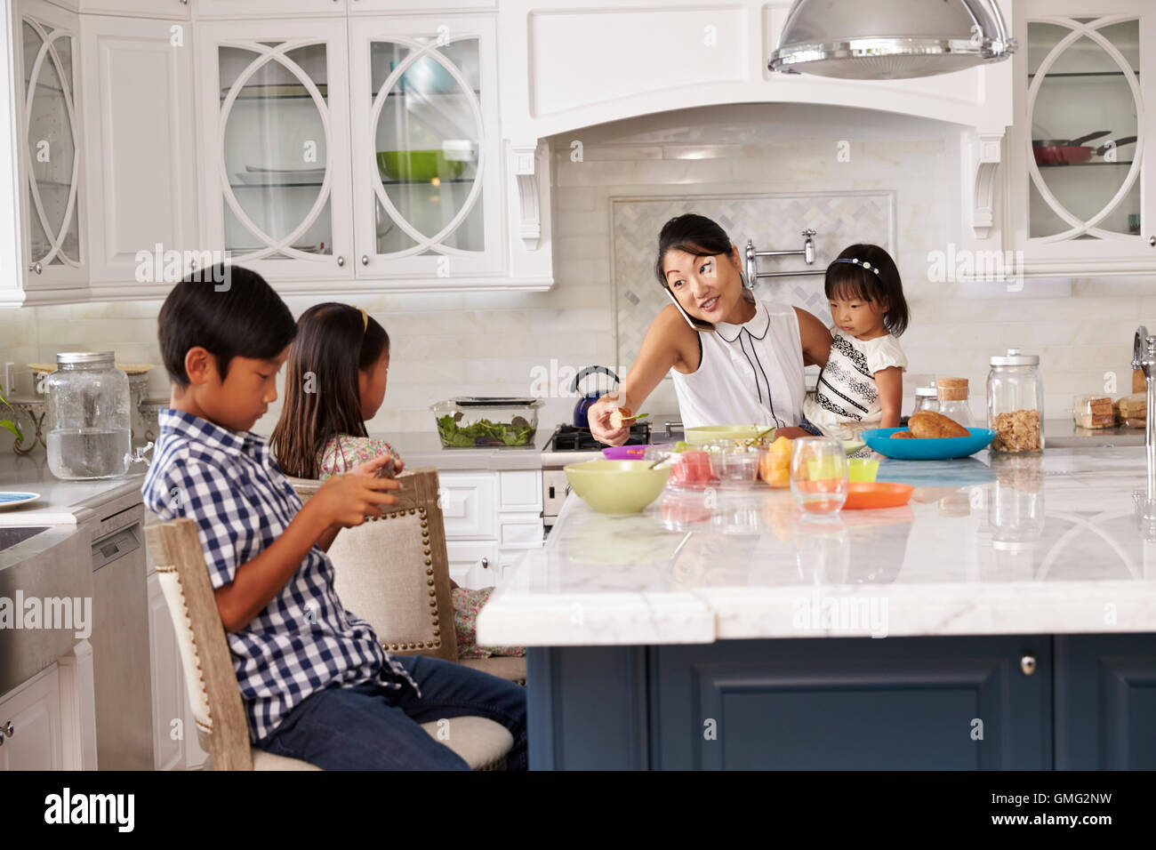 Busy Mother Organizing Children At Breakfast In Kitchen Stock Photo - Alamy