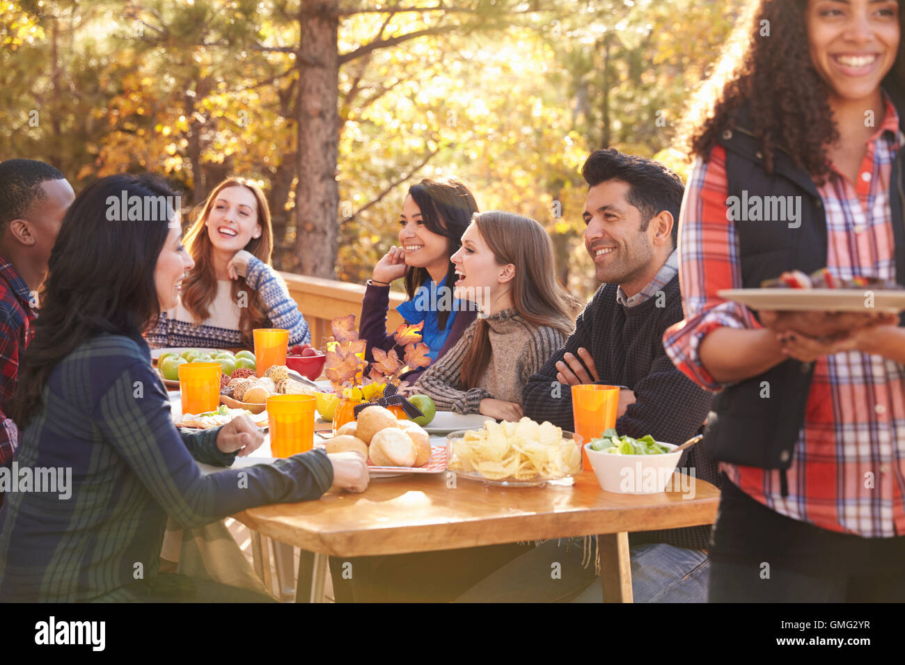 Friends at a barbecue laughing at table, woman in foreground Stock ...