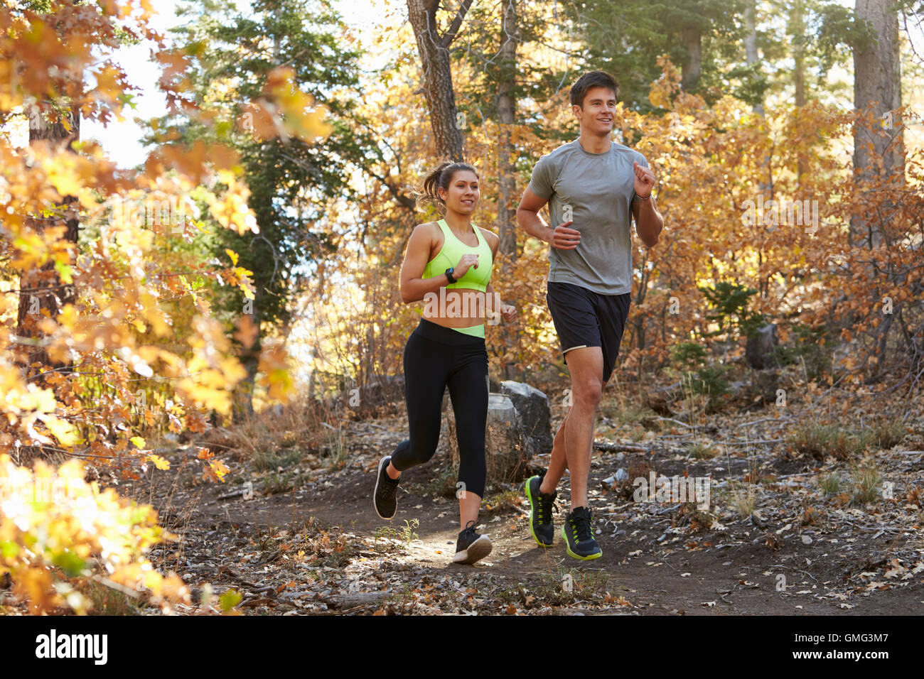 Caucasian woman and man running on a forest trail Stock Photo - Alamy