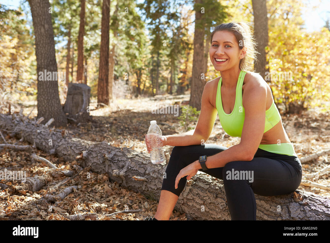 Female runner in a forest takes a break, looking to camera Stock Photo ...
