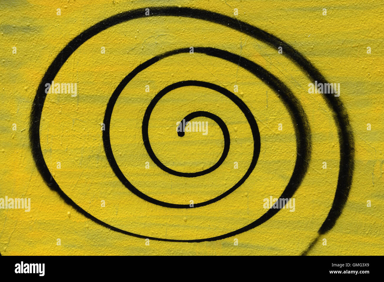 Spray painted spiral on textured wall background. Abstract geometric ...