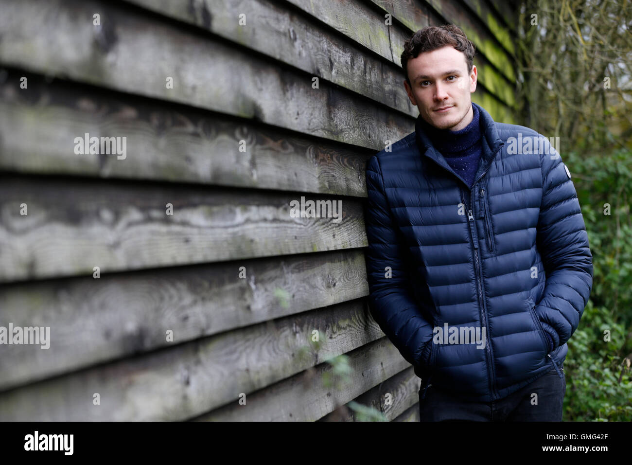 Outdoor Portrait Of Man Leaning Against Wooden Building Stock Photo - Alamy