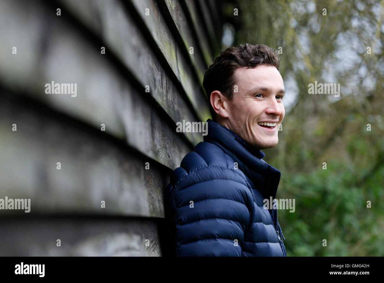 Outdoor Portrait Of Man Leaning Against Wooden Building Stock Photo - Alamy