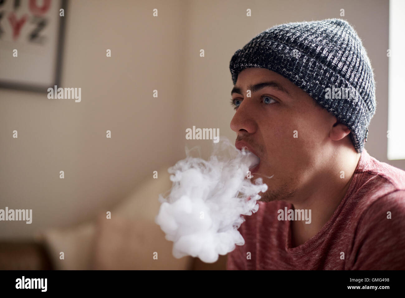 Young Man Exhaling Whilst Using Vapourizer Stock Photo - Alamy