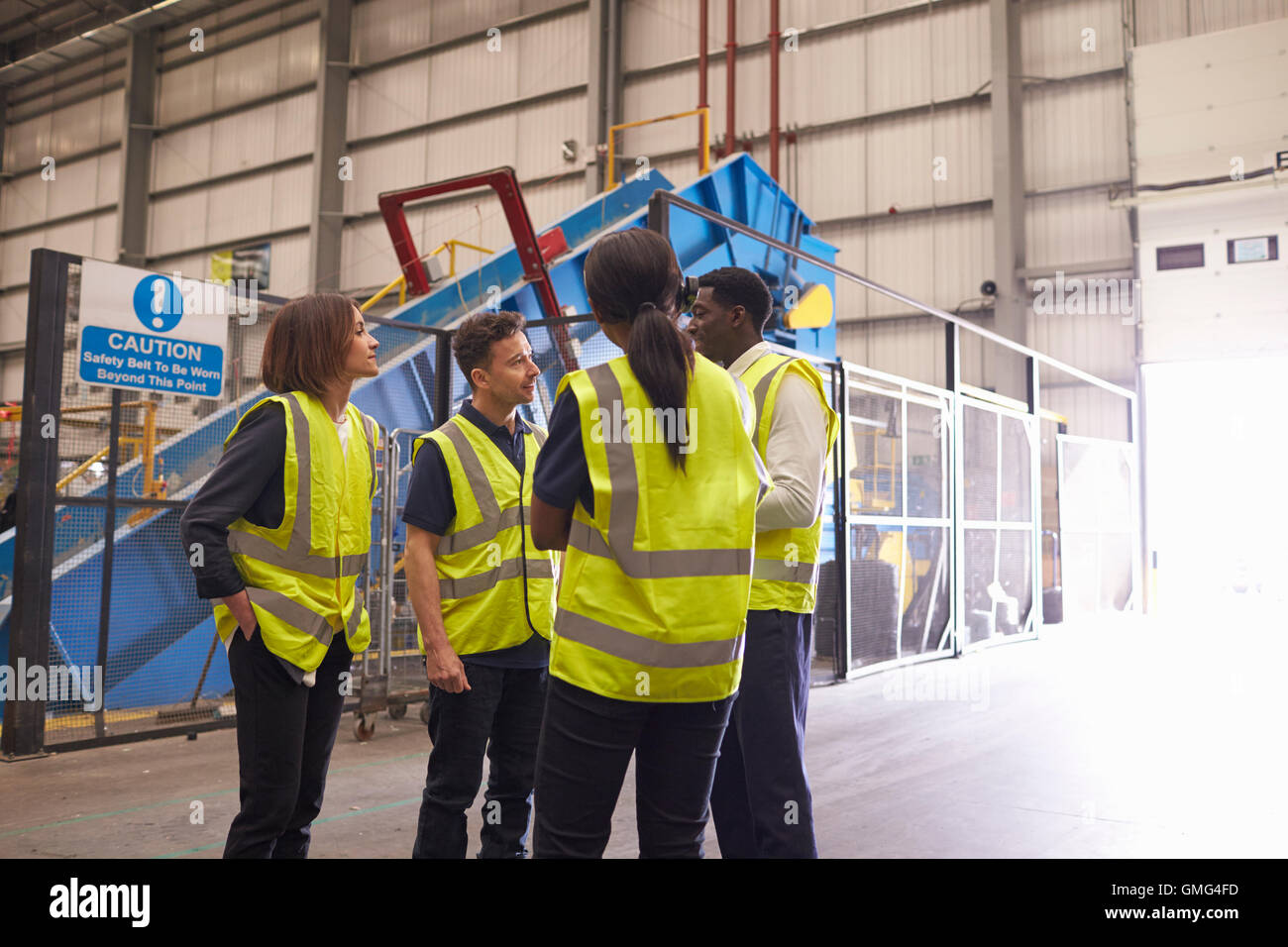 Four coworkers in discussion in an industrial interior Stock Photo - Alamy