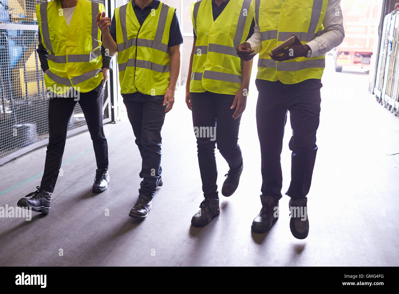 Four colleagues walk in an industrial interior, low section Stock Photo ...