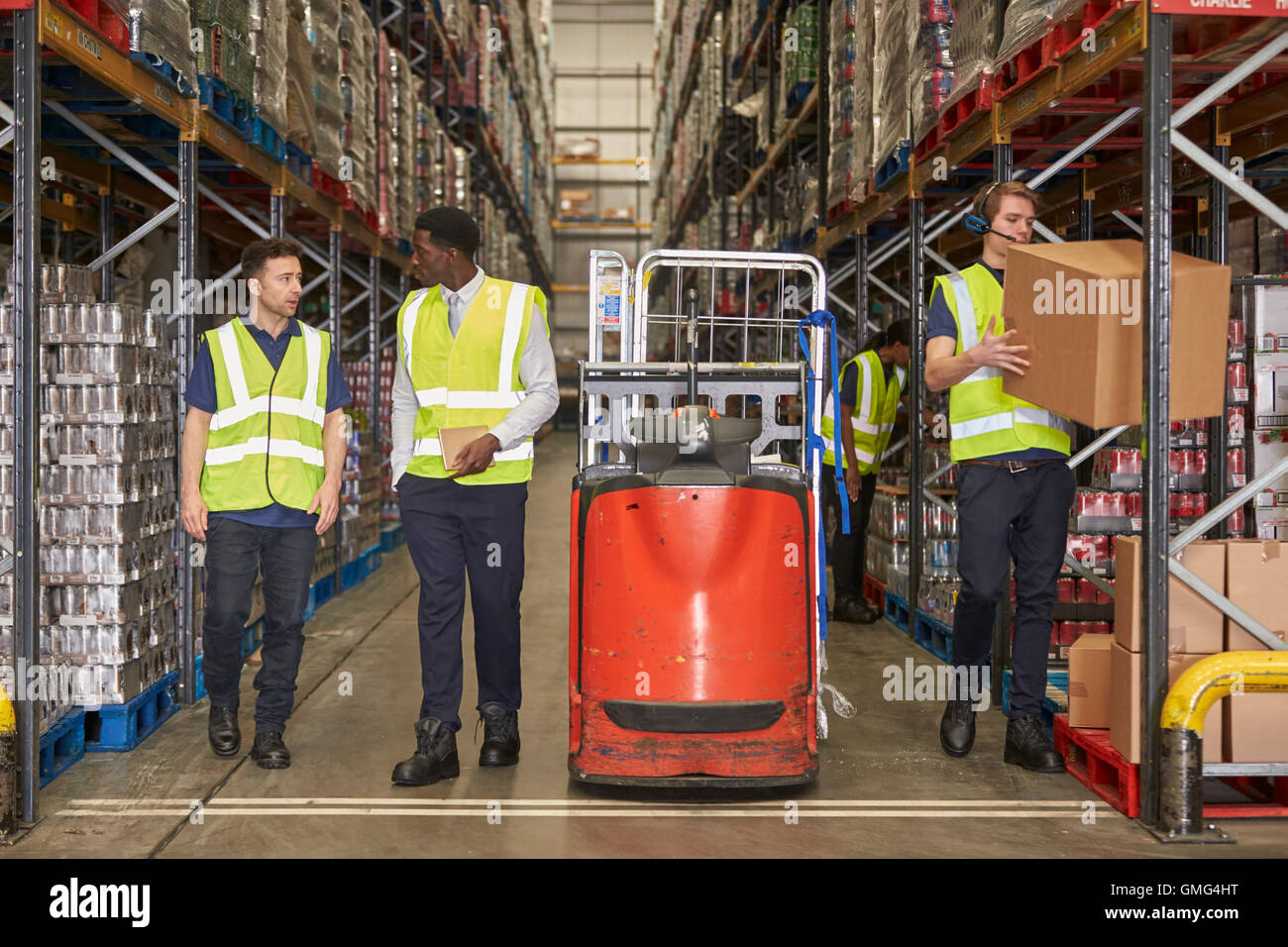 Staff at work in the aisle of a busy distribution warehouse Stock Photo ...