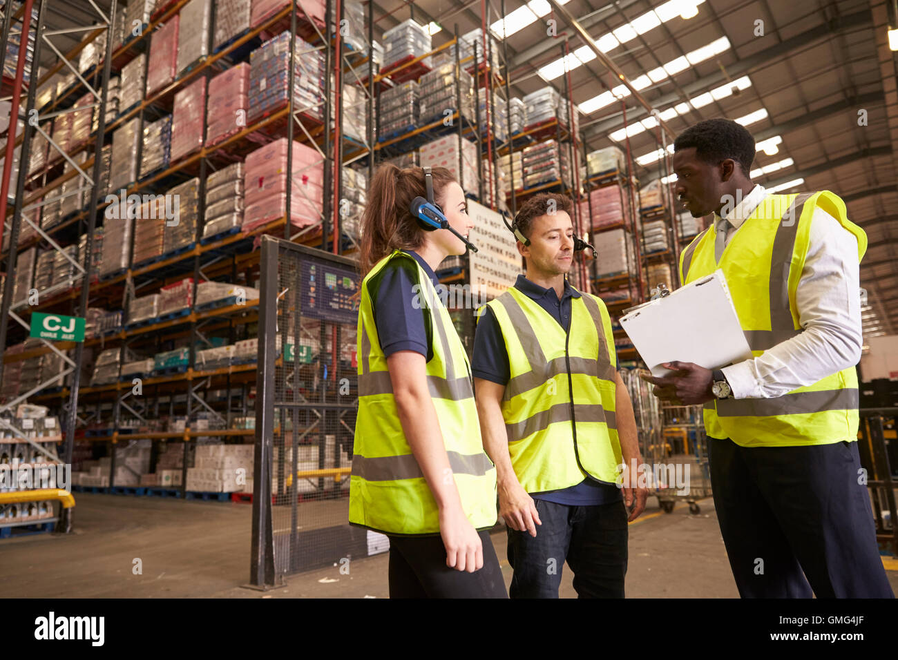 Distribution warehouse manager in discussion with colleagues Stock ...