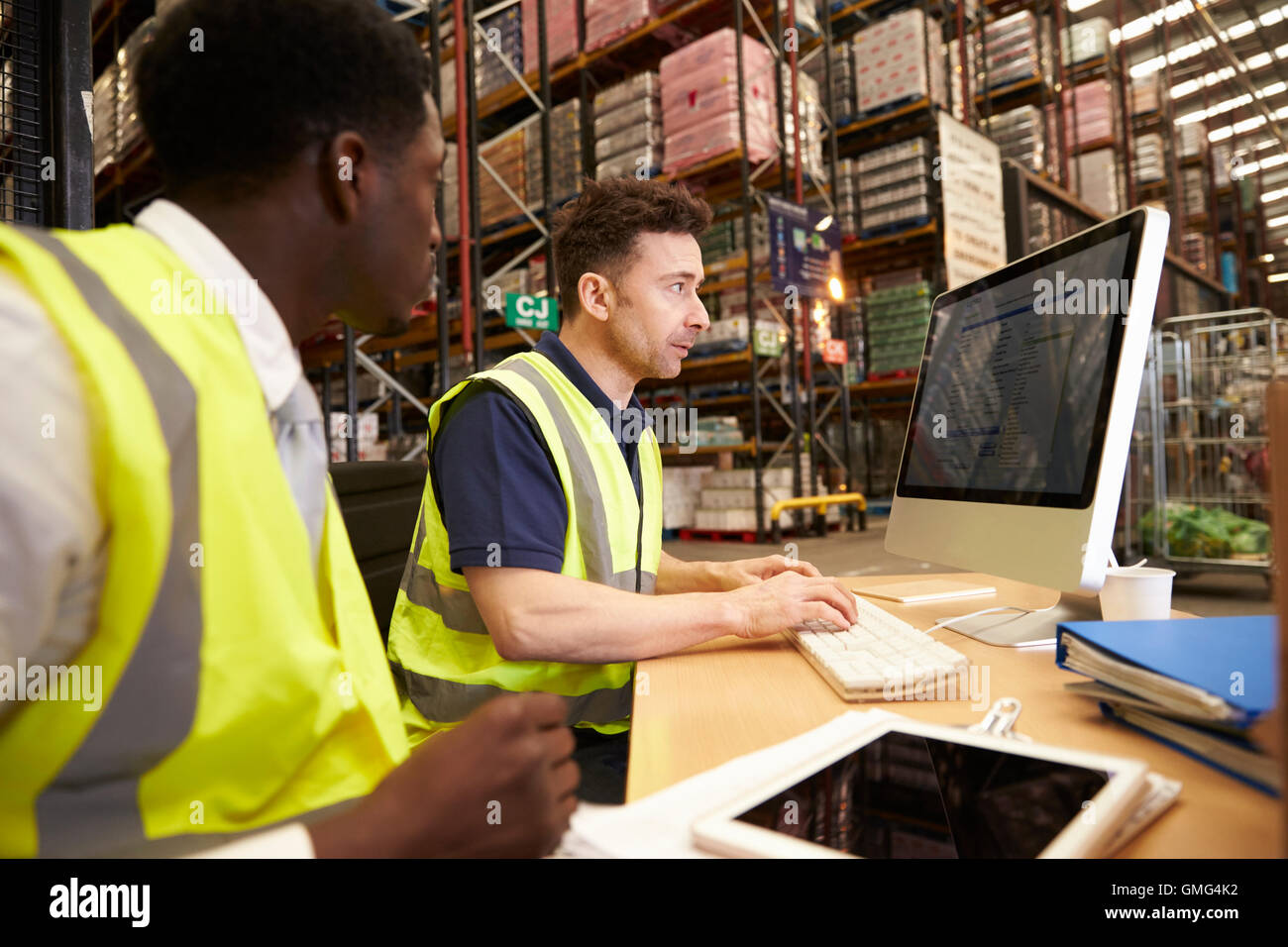 Staff working in on-site office at a distribution warehouse Stock Photo ...