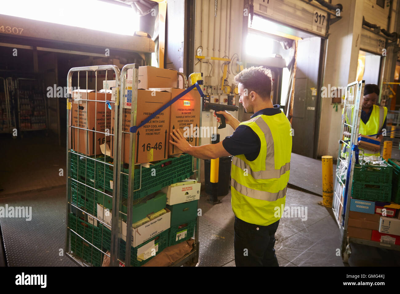 Man in a warehouse holds and scans a box for delivery Stock Photo - Alamy