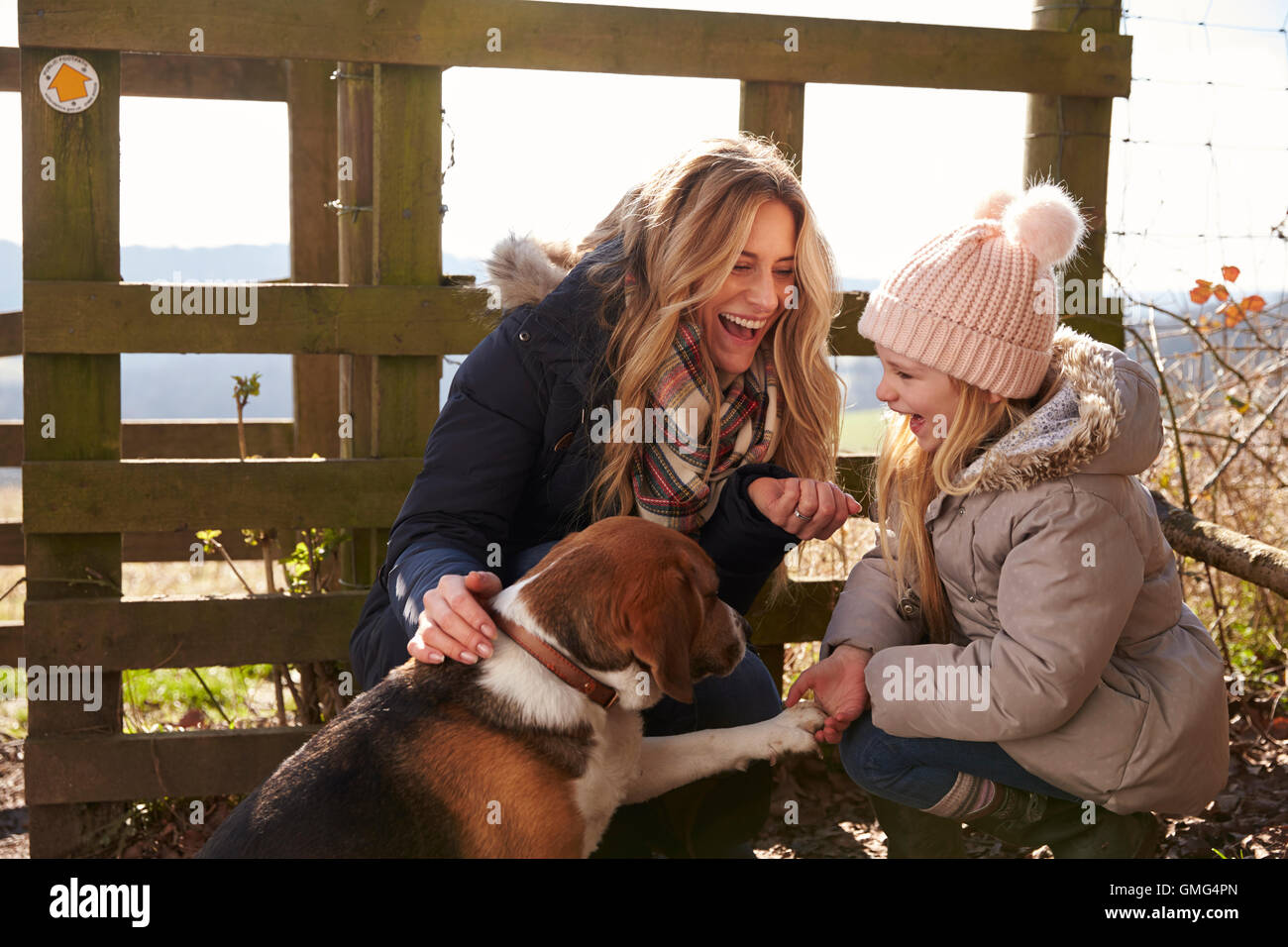 Mother and daughter play with dog in countryside, close up Stock Photo - Alamy