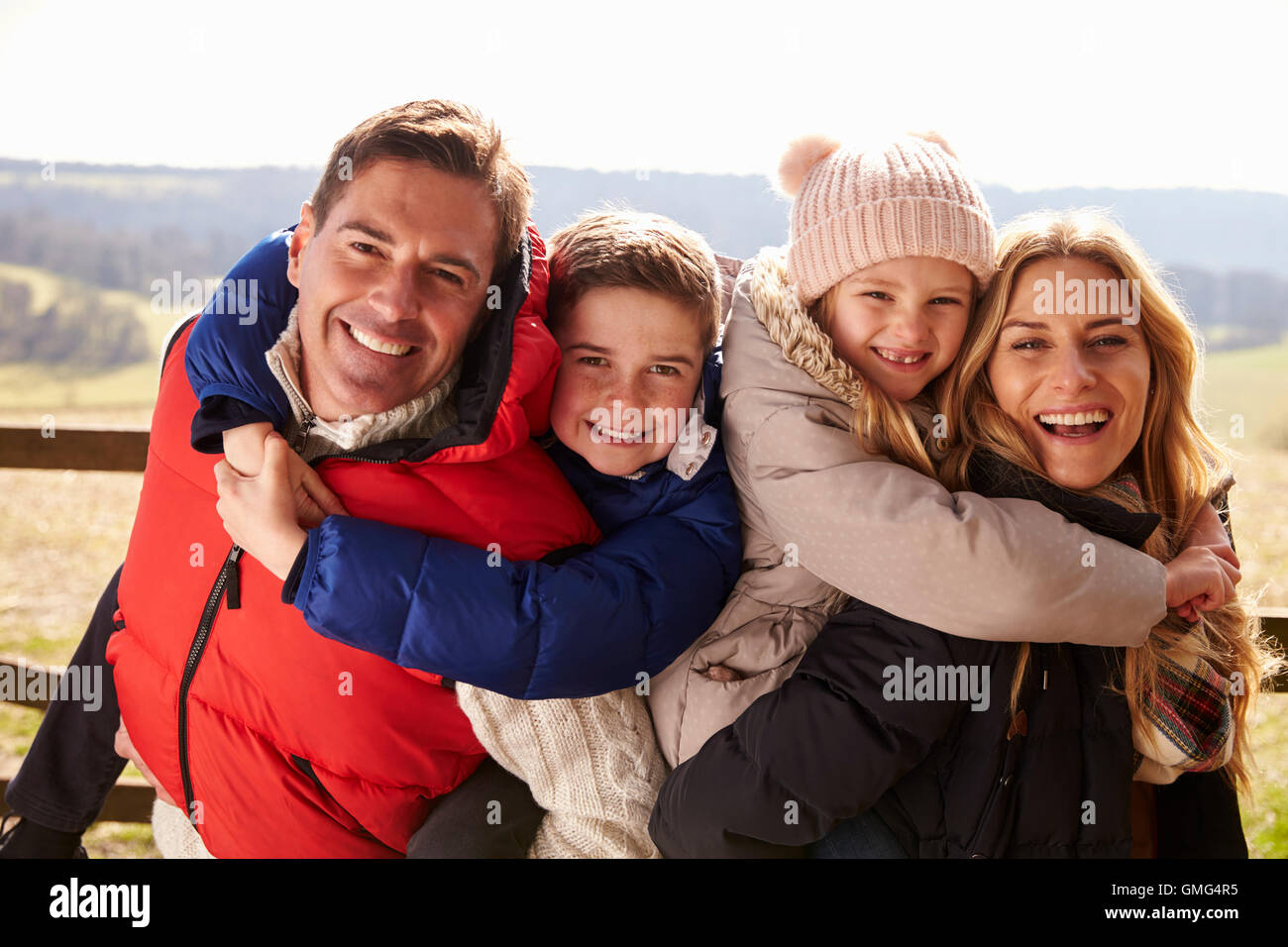 Parents piggy back kids in the countryside looking to camera Stock ...