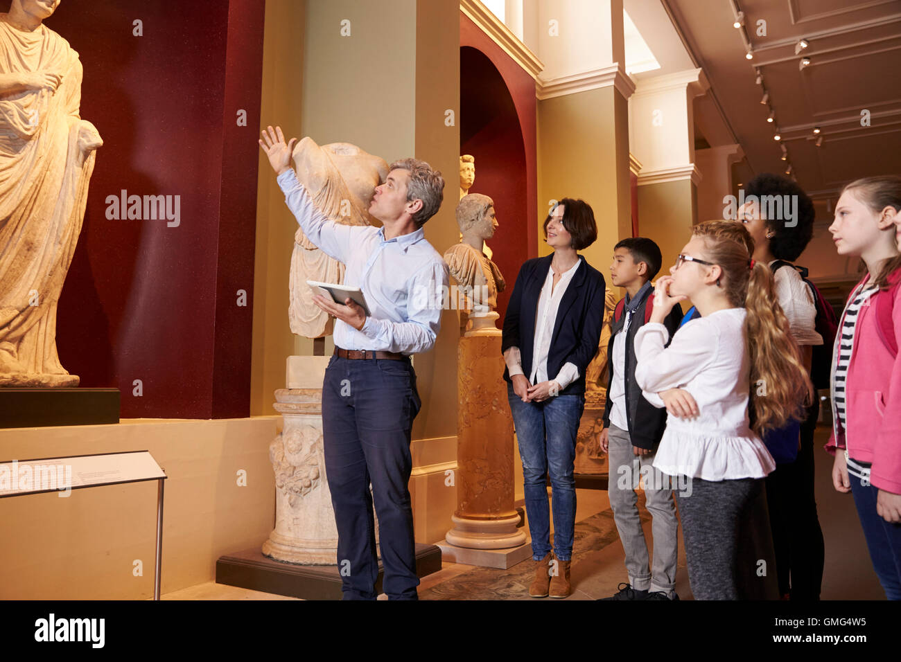 Pupils And Teacher On School Field Trip To Museum With Guide Stock ...