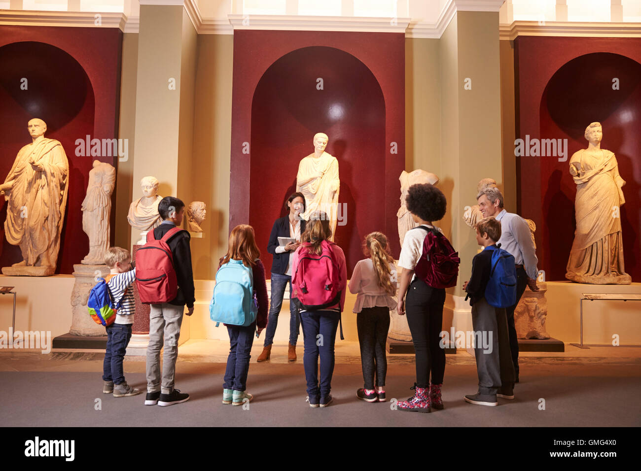 Pupils And Teacher On School Field Trip To Museum With Guide Stock ...