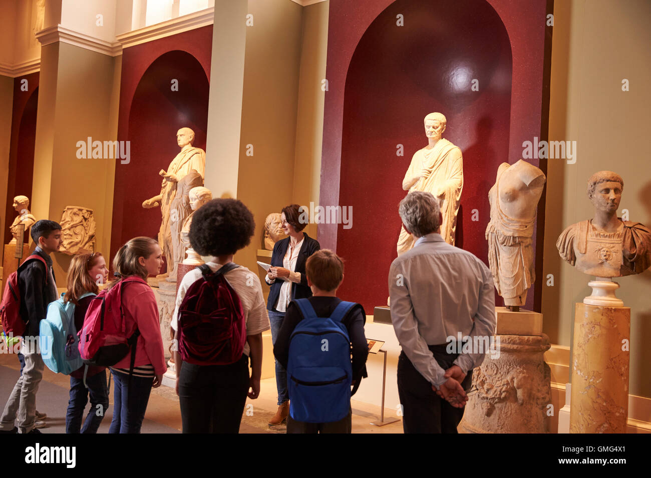 Pupils And Teacher On School Field Trip To Museum With Guide Stock ...