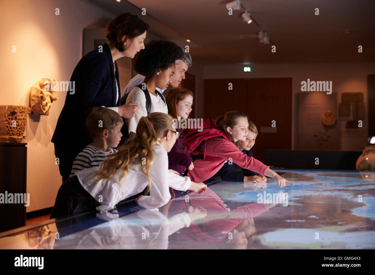 Pupils On School Field Trip To Museum Looking At Map Stock Photo - Alamy