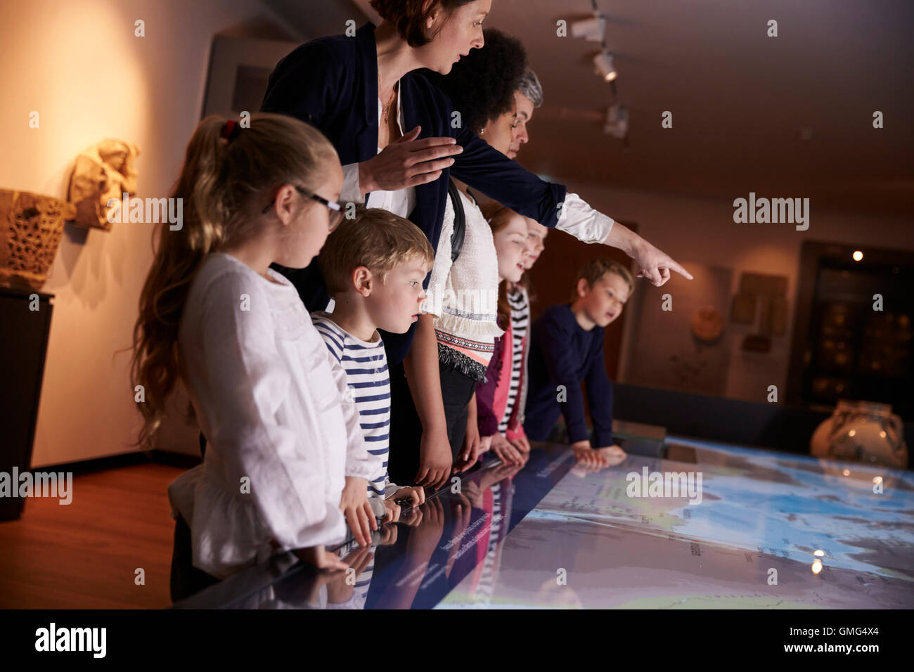 Pupils On School Field Trip To Museum Looking At Map Stock Photo - Alamy