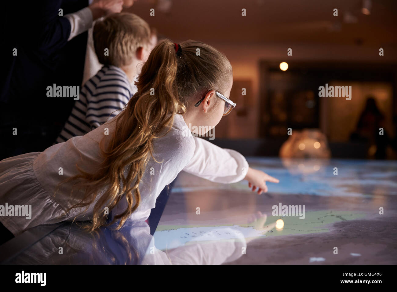 Pupils On School Field Trip To Museum Looking At Map Stock Photo - Alamy