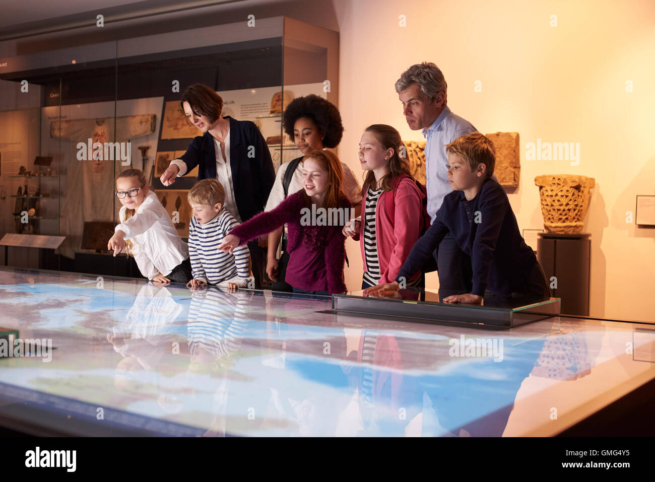 Pupils On School Field Trip To Museum Looking At Map Stock Photo - Alamy