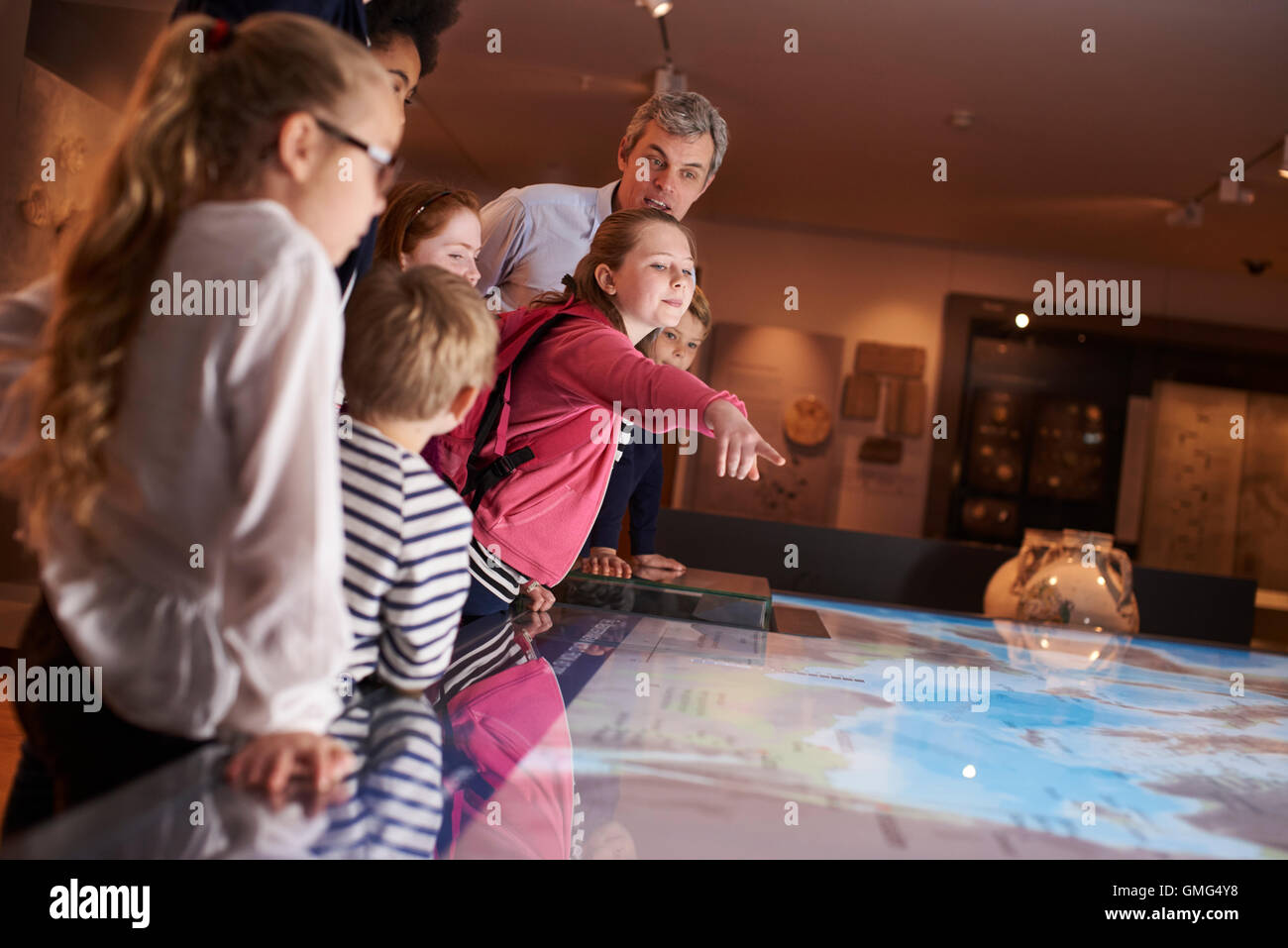 Pupils On School Field Trip To Museum Looking At Map Stock Photo - Alamy