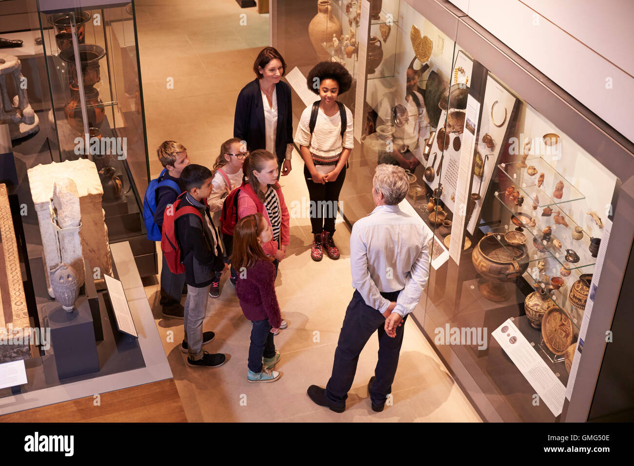 Students Looking At Artifacts In Case On Trip To Museum Stock Photo - Alamy