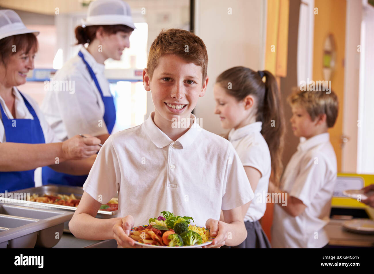 Caucasian schoolboy holds plate of food in school cafeteria Stock Photo ...