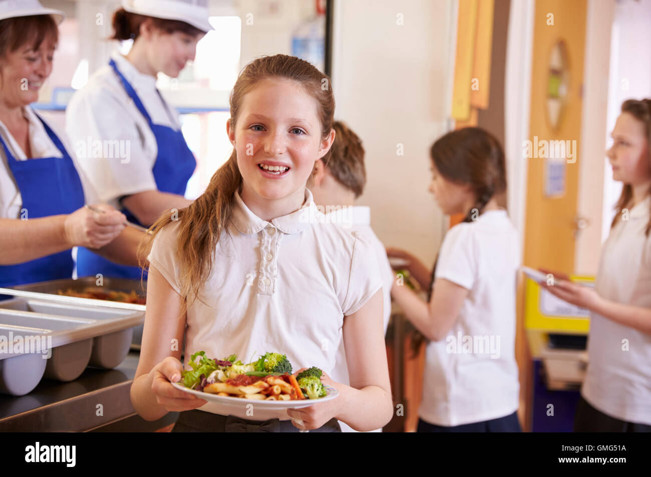 Caucasian schoolgirl holds plate of food in school cafeteria Stock ...