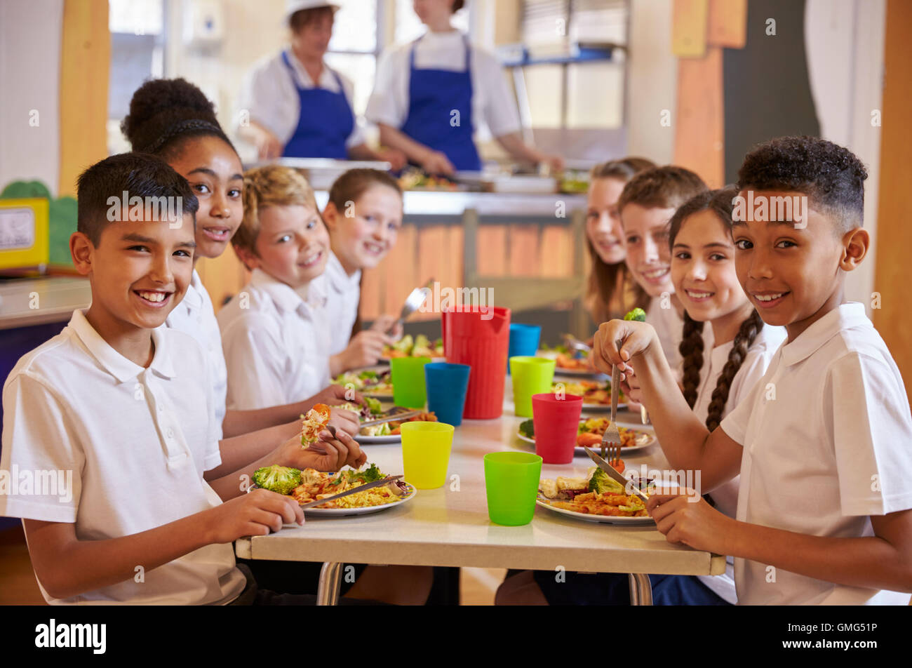 Kids at a table in a primary school cafeteria look to camera Stock ...