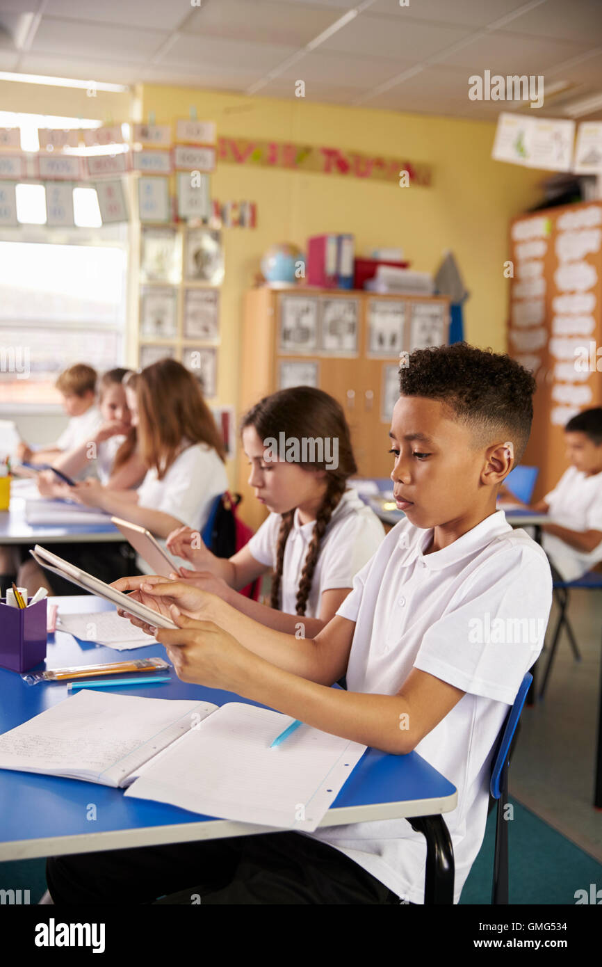 Kids use tablet computers in primary school class, vertical Stock Photo ...