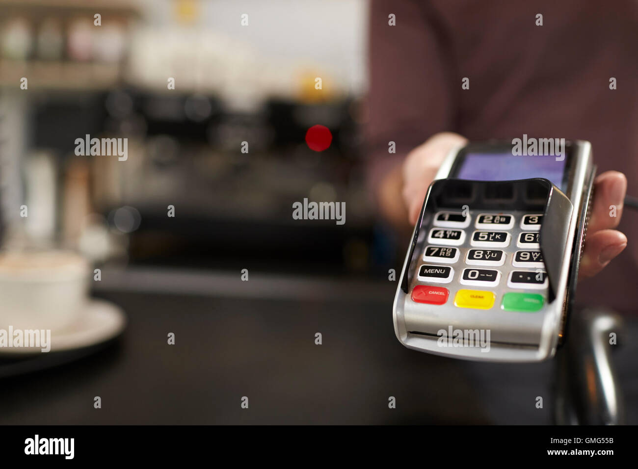 Man behind cafe counter offers credit card reader, close up Stock Photo ...